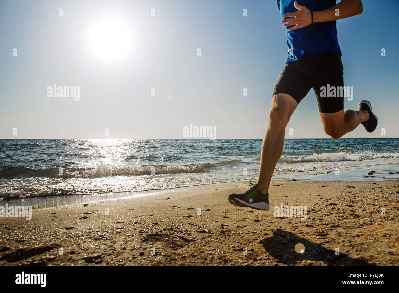 dynamic running man runner on sandy beach Stock Photo - Alamy