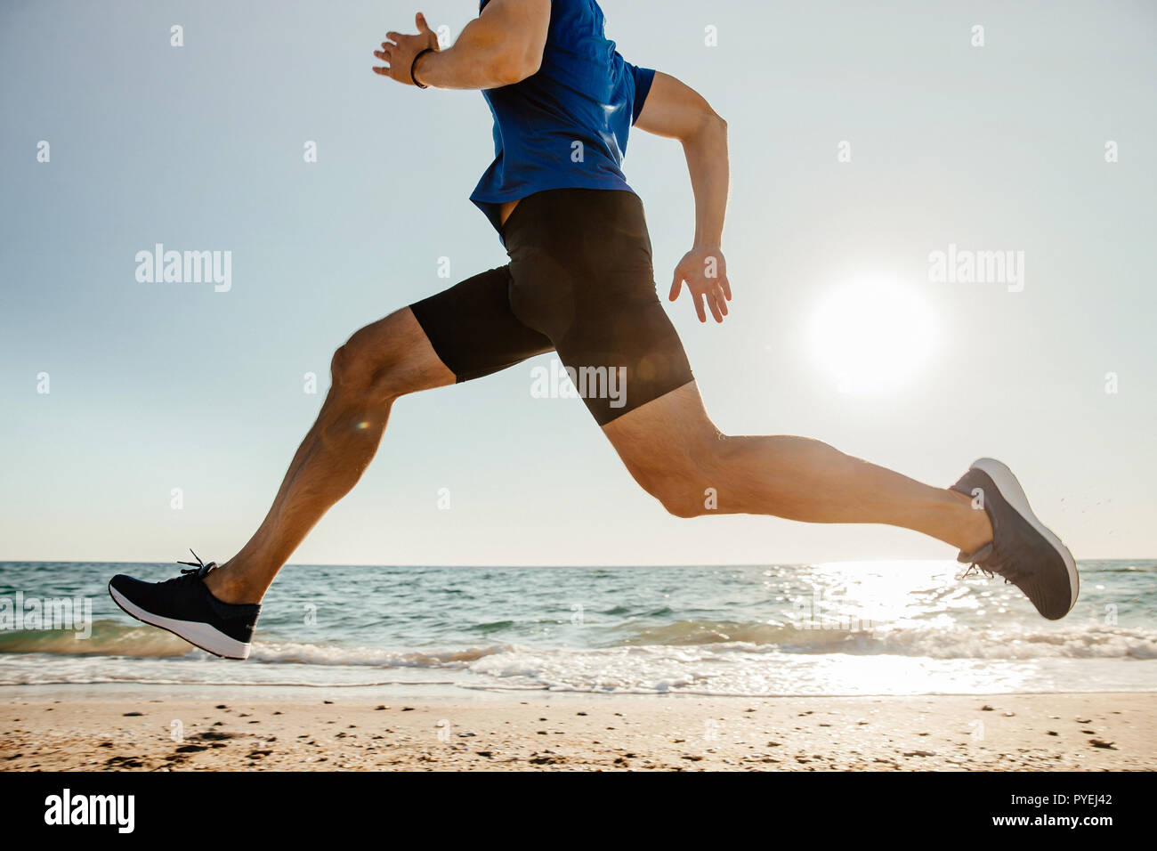 close-up feet runner man running on beach in sunlight Stock Photo - Alamy