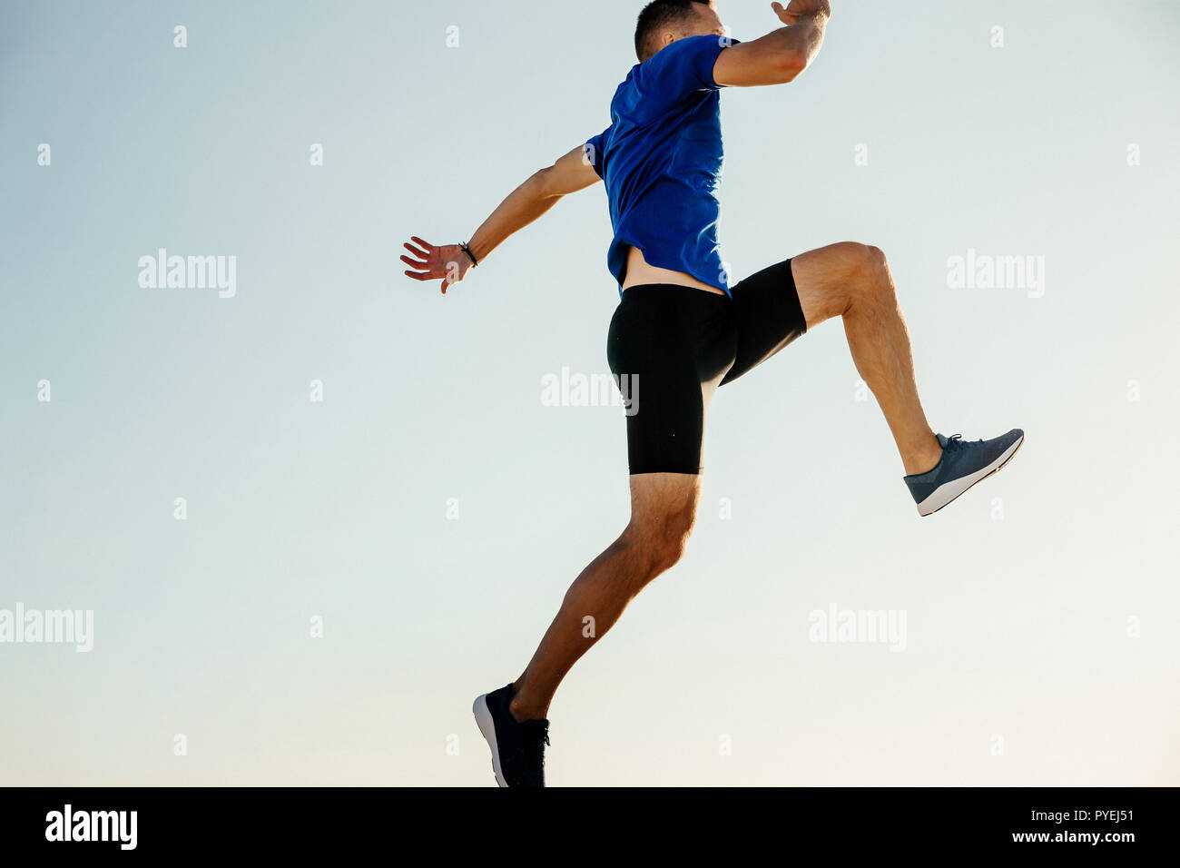male athlete jumping on blue sky background. freedom concept Stock ...