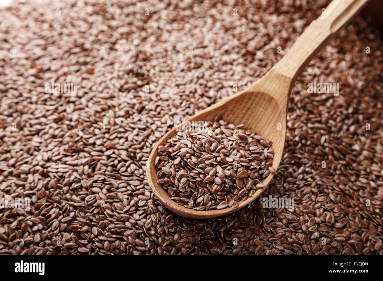 flax seeds scattered as a background and poured into a spoon. space for text Stock Photo - Alamy