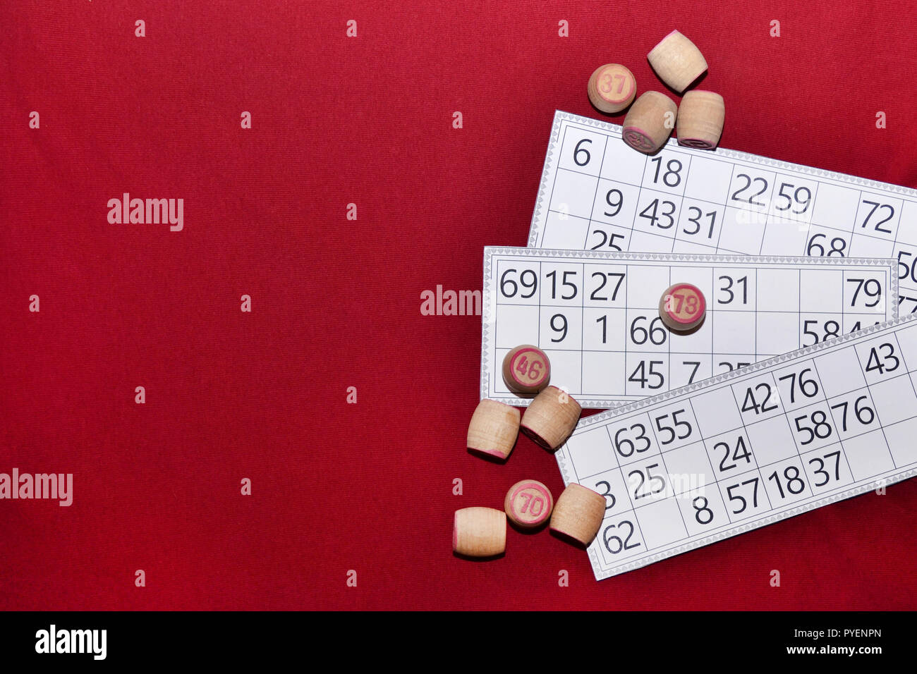 The game of bingo consists of cards and barrels with numbers on a red ...