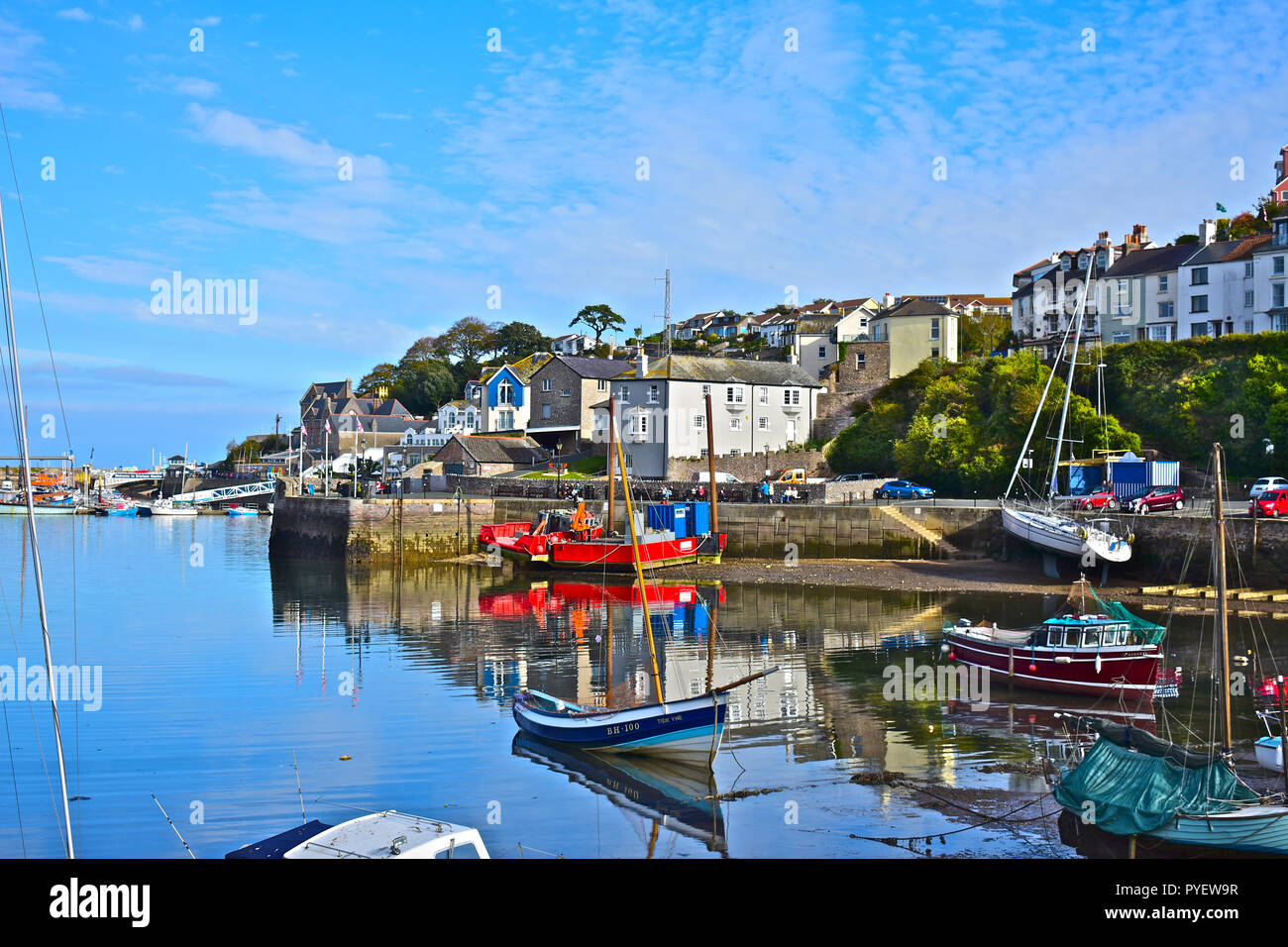 A view of the quayside at Brixham with the reflections of the boats in ...