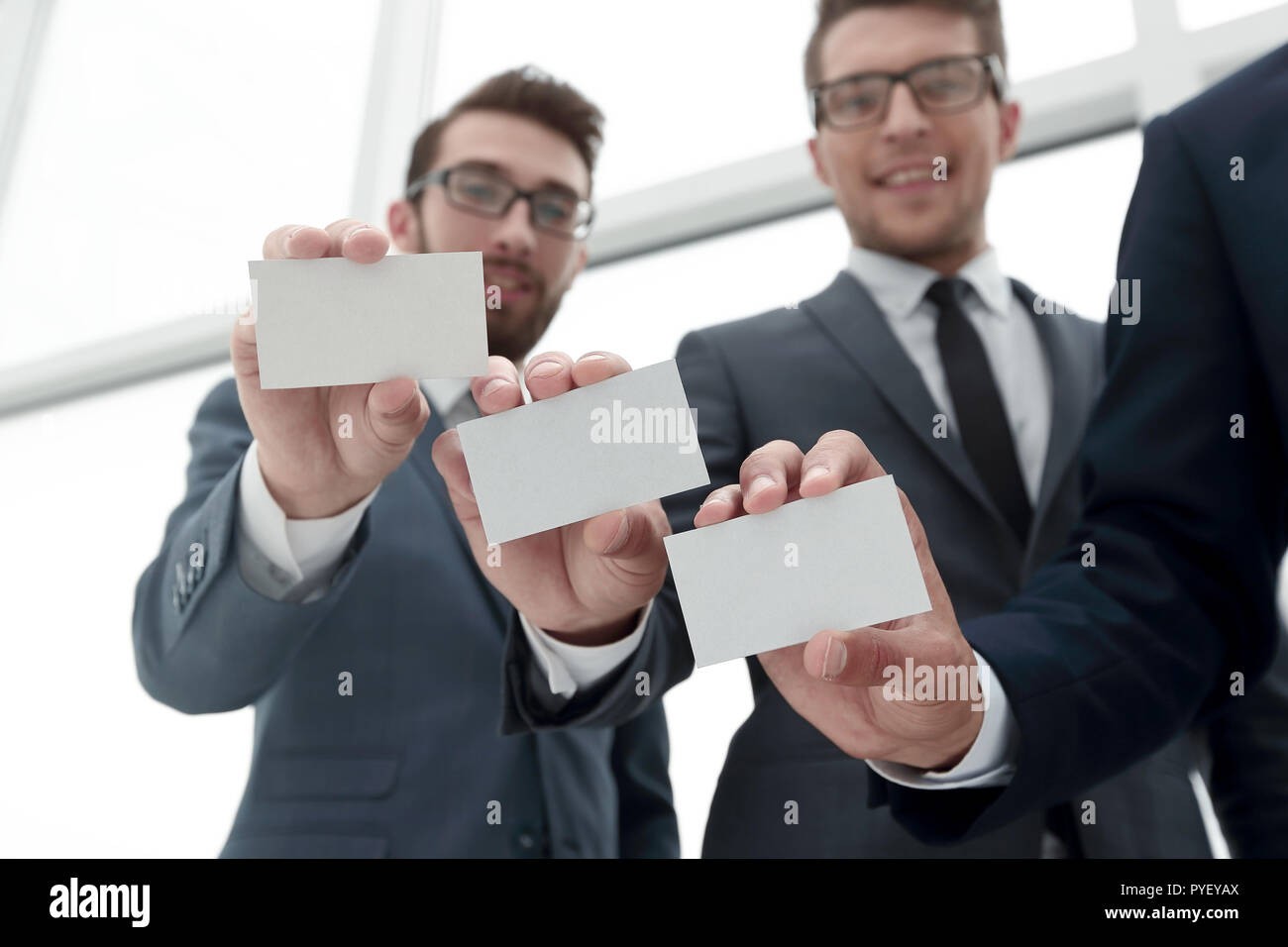 three young business partners showing their business cards Stock Photo ...