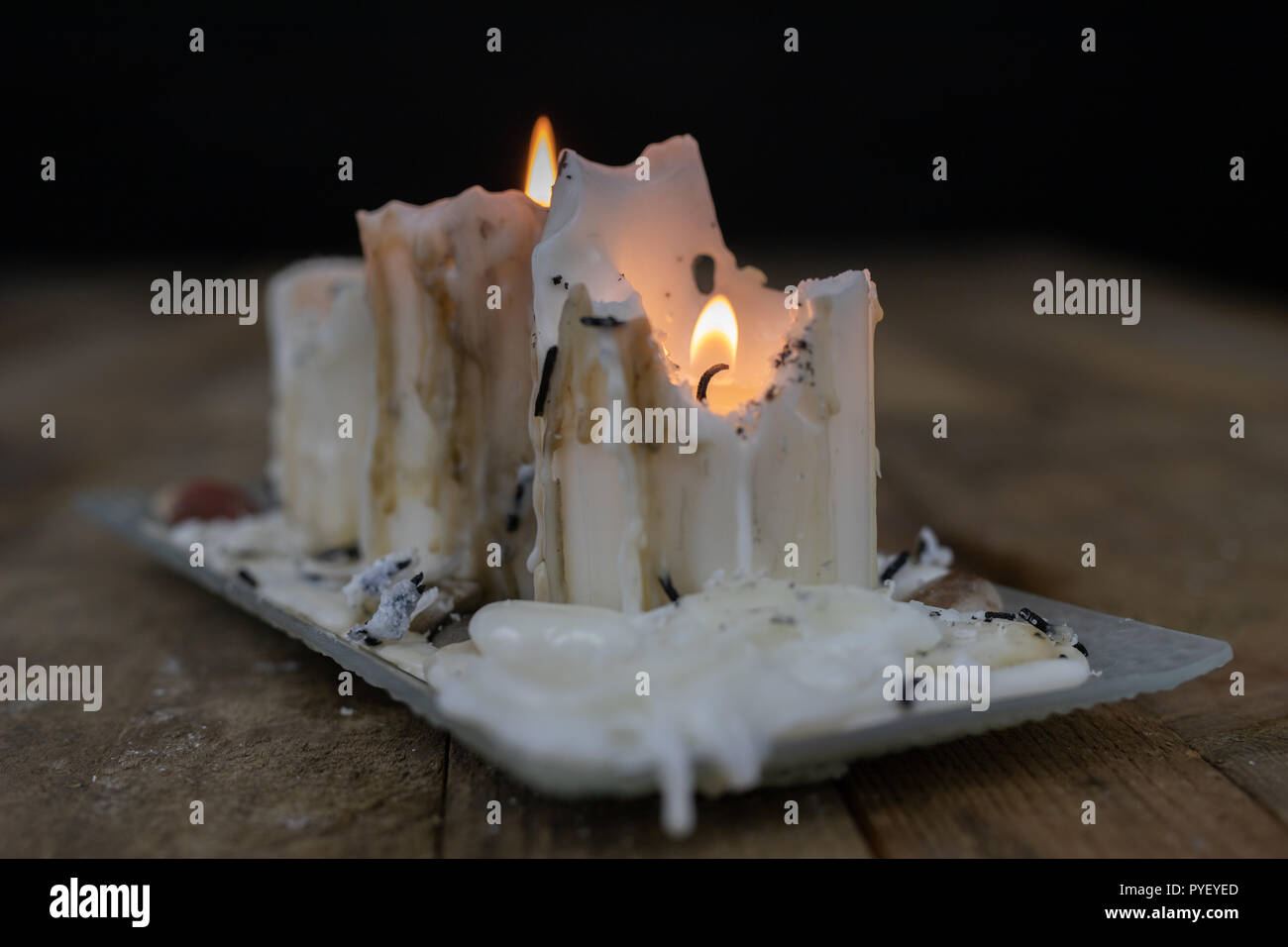 Old candles with dirty wax on a wooden table. Burning dirty ...