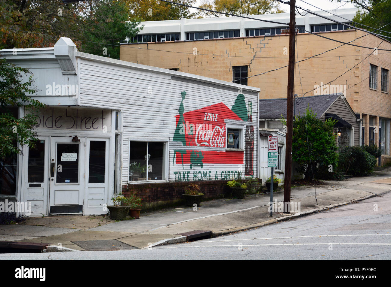 A classic sign for Coca Cola on the side of an old corner store in the ...