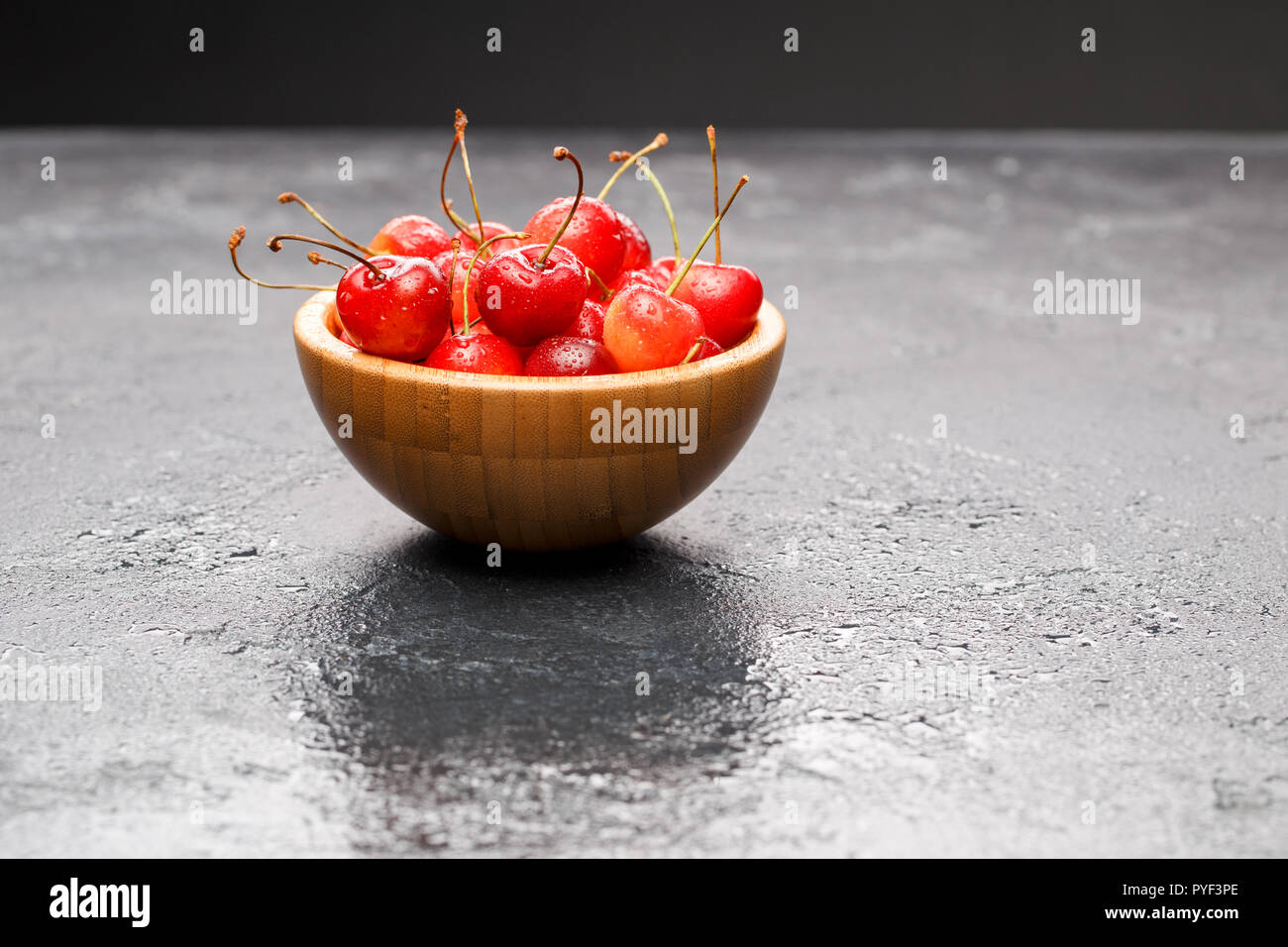 Photo of red cherry in wooden cup Stock Photo - Alamy