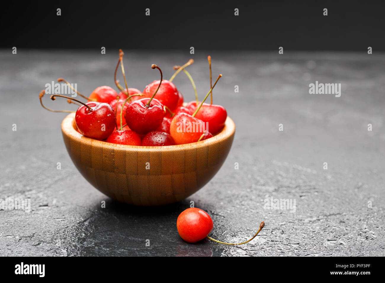 Photo of red cherry in wooden cup Stock Photo - Alamy