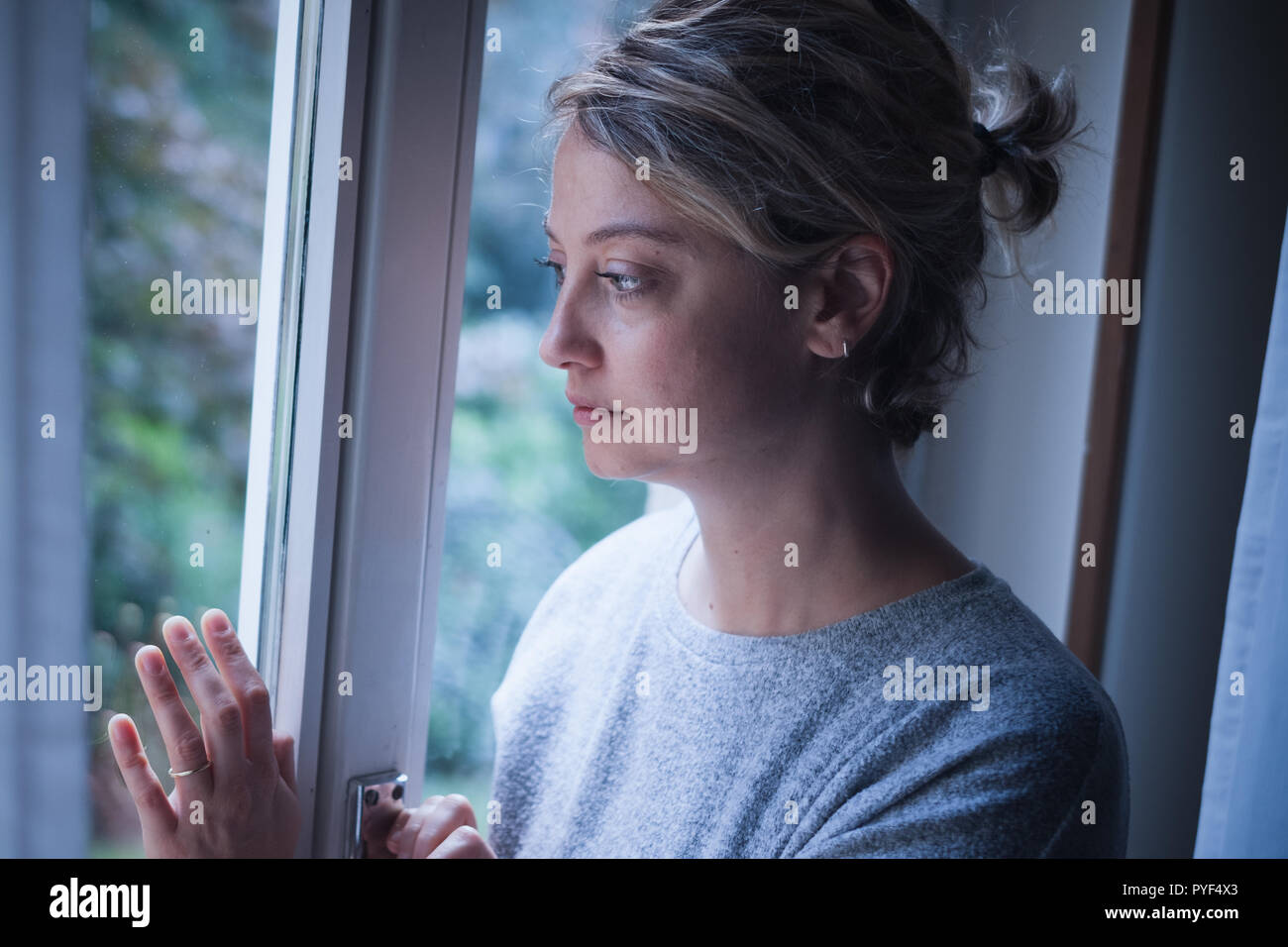 Sad woman portrait looking out the window Stock Photo - Alamy