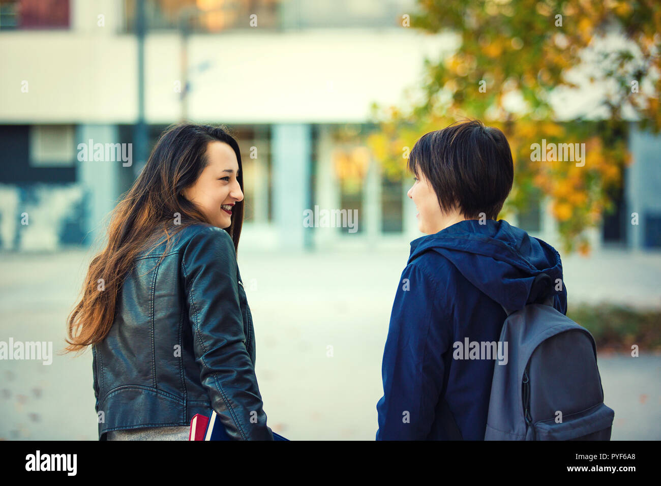 Student friendship as two girls talking and smile outdoors in the ...
