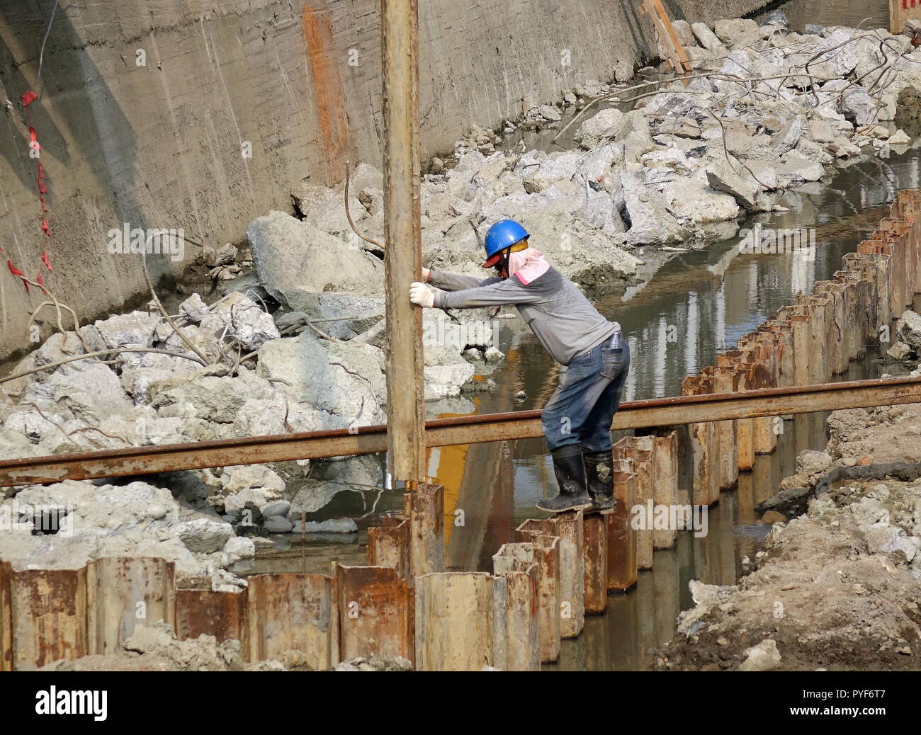 KAOHSIUNG, TAIWAN -- OCTOBER 10, 2018: A construction worker guides the ...