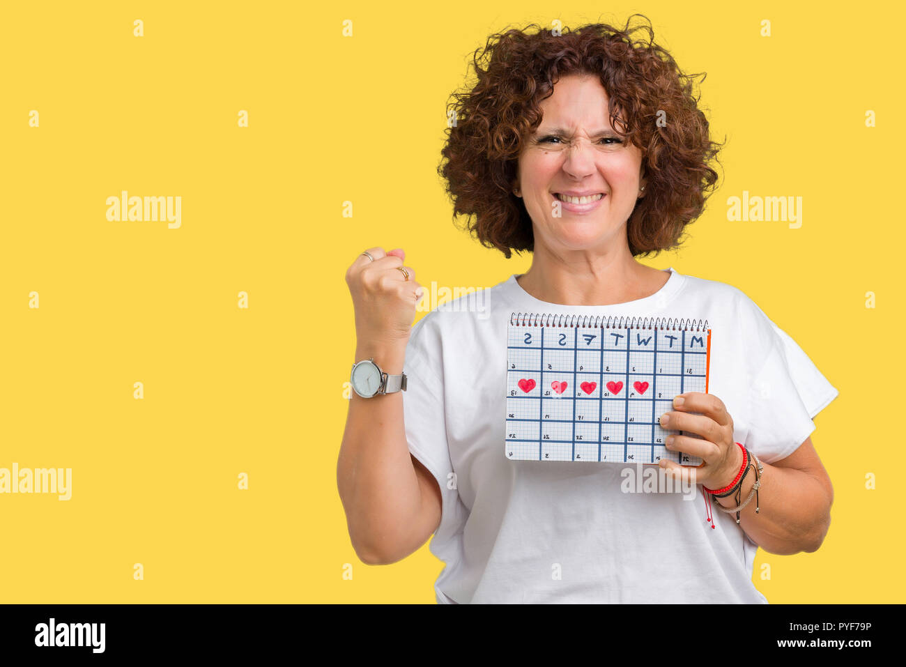 Middle ager senior woman holding menstruation calendar over isolated ...