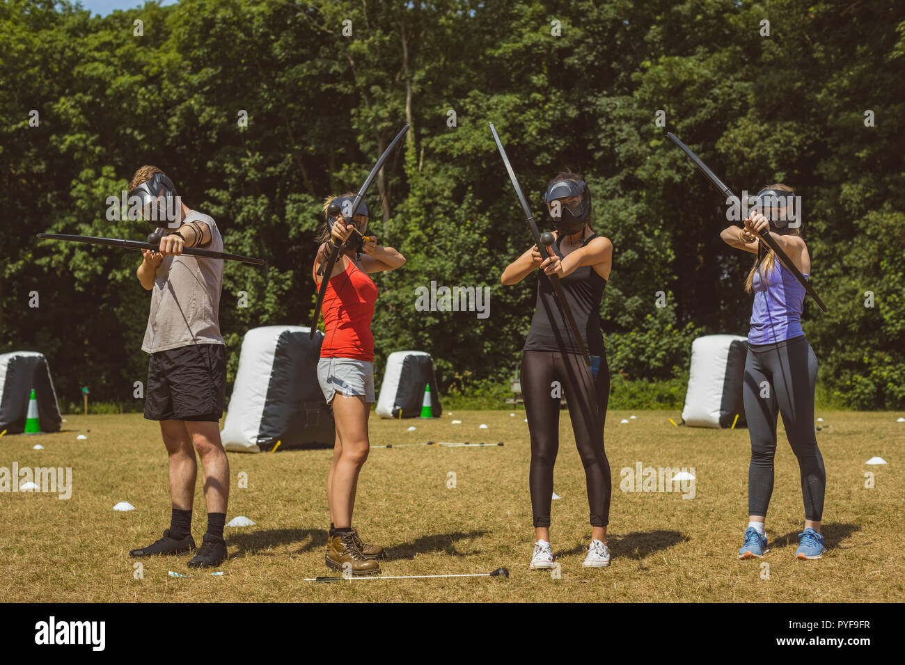 Group of people practicing archery at boot camp Stock Photo - Alamy