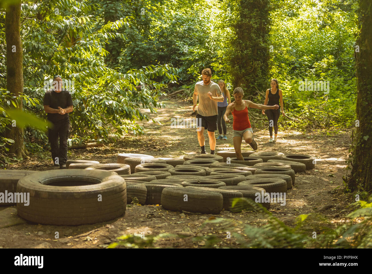 Fit people training over tyre obstacle course Stock Photo - Alamy