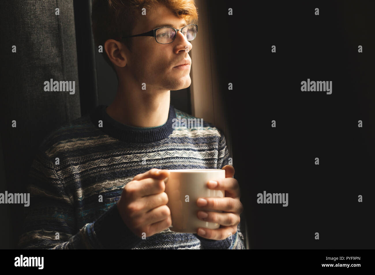 Man having coffee while looking through window Stock Photo - Alamy