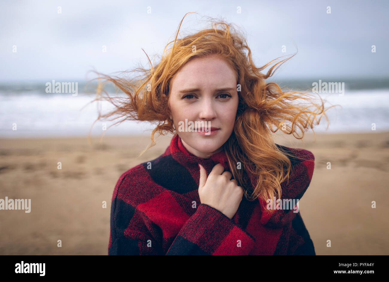 Redhead woman standing in the beach Stock Photo - Alamy