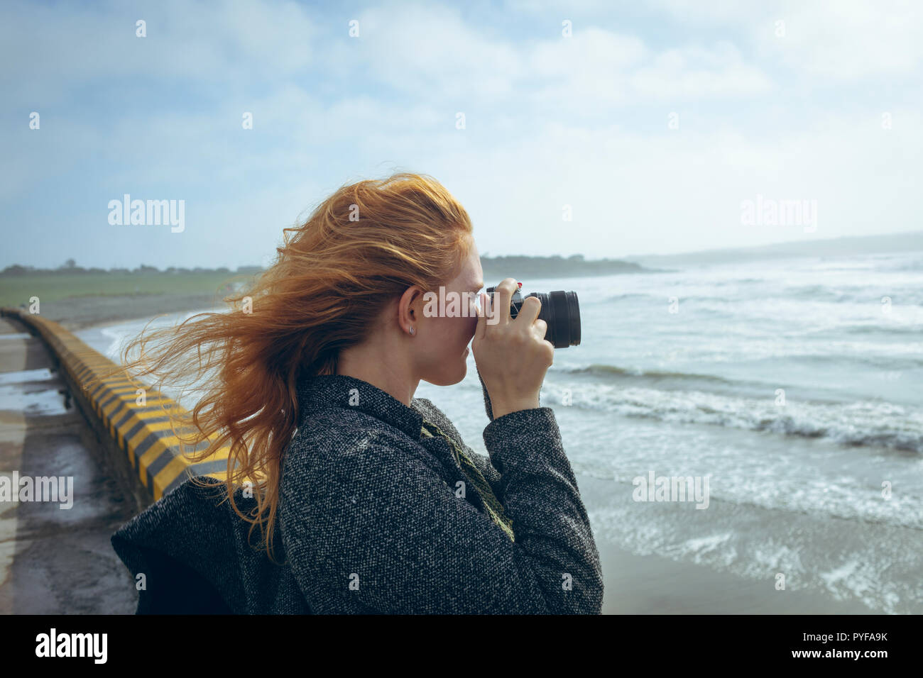 Woman clicking photo with camera in the beach Stock Photo - Alamy