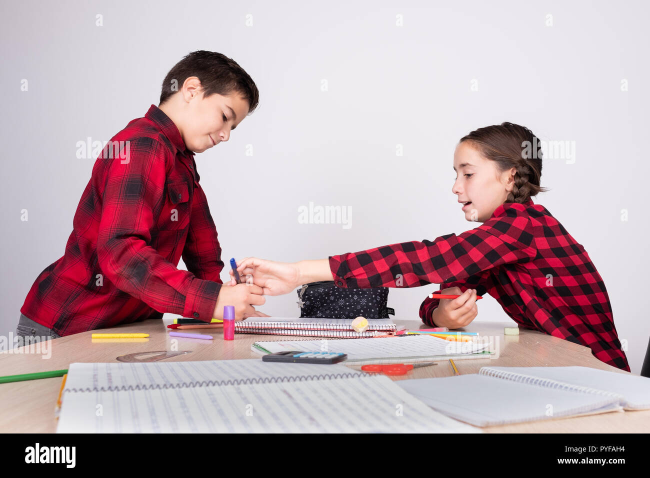 little girl removing pencil to child at school Stock Photo - Alamy