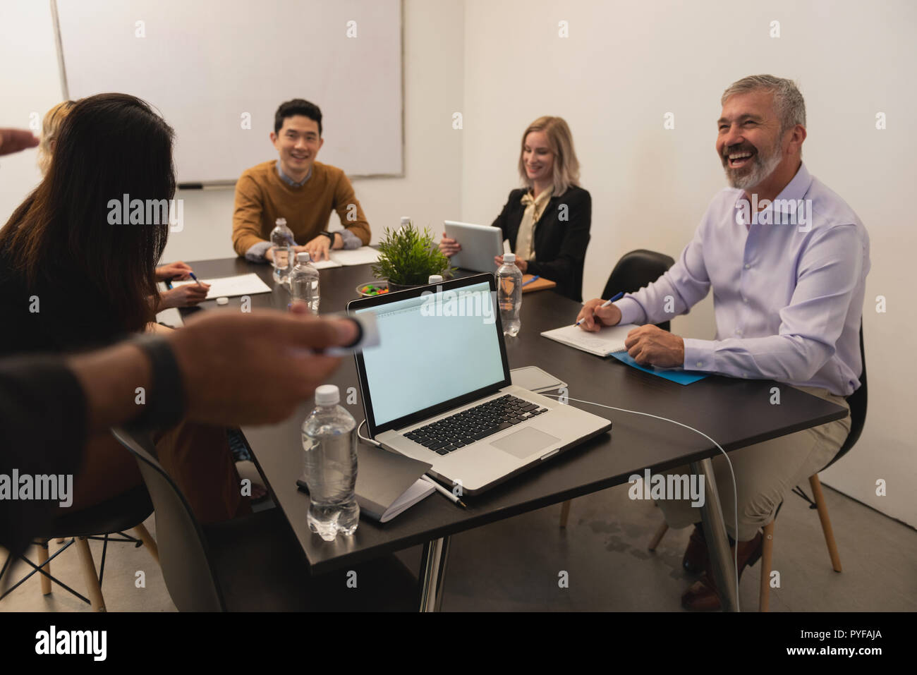 Executives discussing in meeting room at office Stock Photo - Alamy