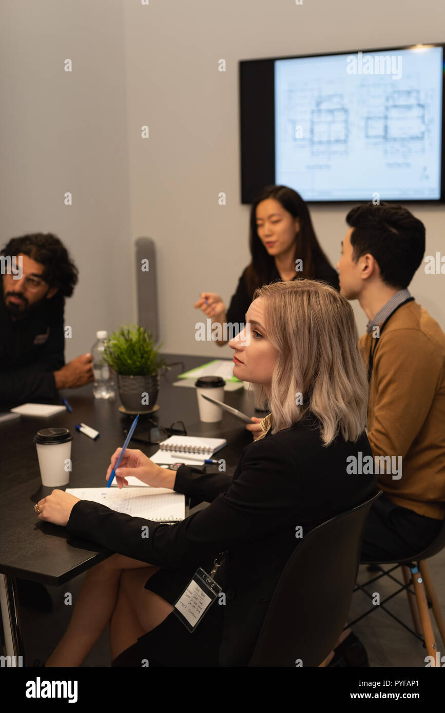 Executives working on table in conference room Stock Photo - Alamy