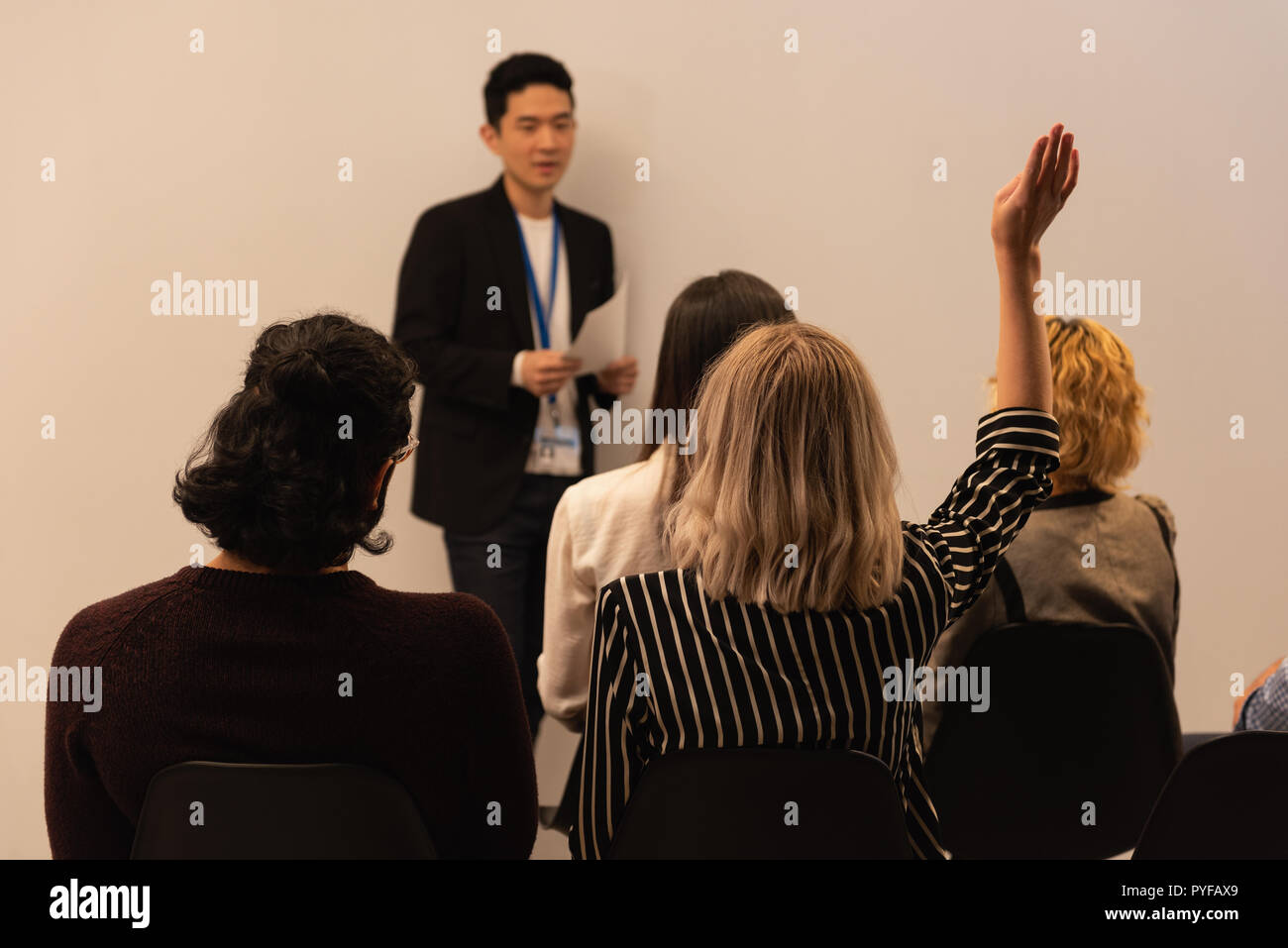 Executive raising hand during meeting Stock Photo - Alamy