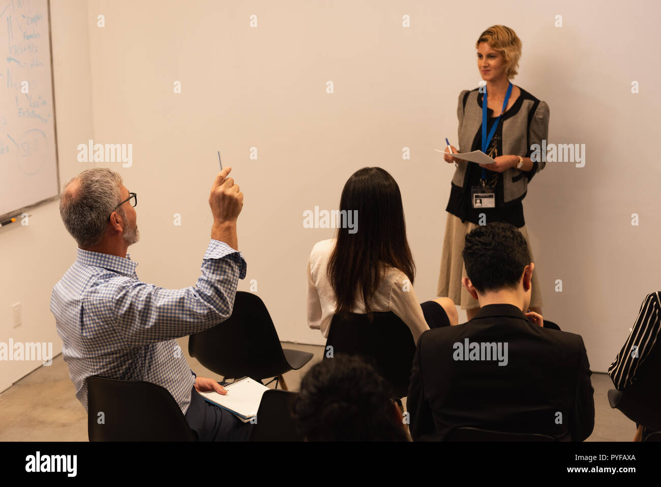 Executive raising hand during meeting Stock Photo - Alamy