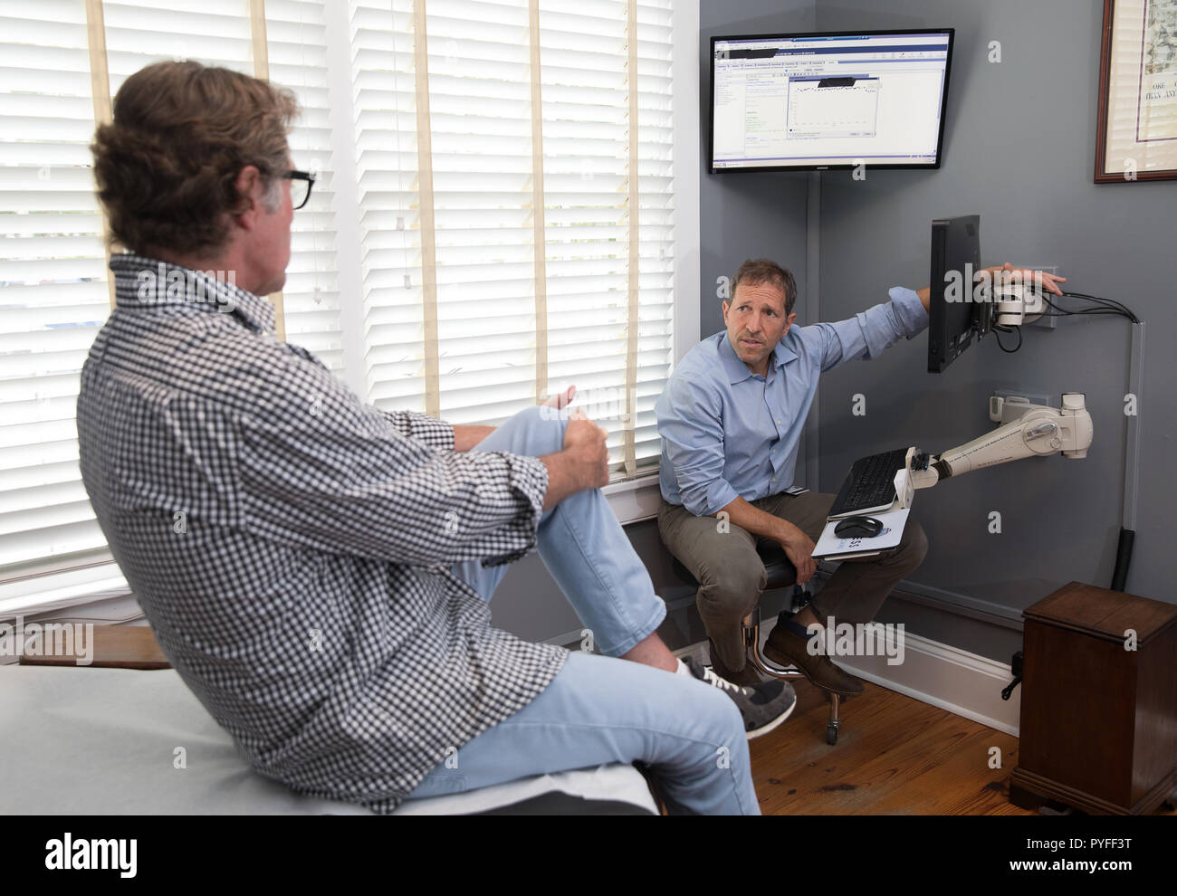 Doctor visits with patient in exam room Stock Photo - Alamy