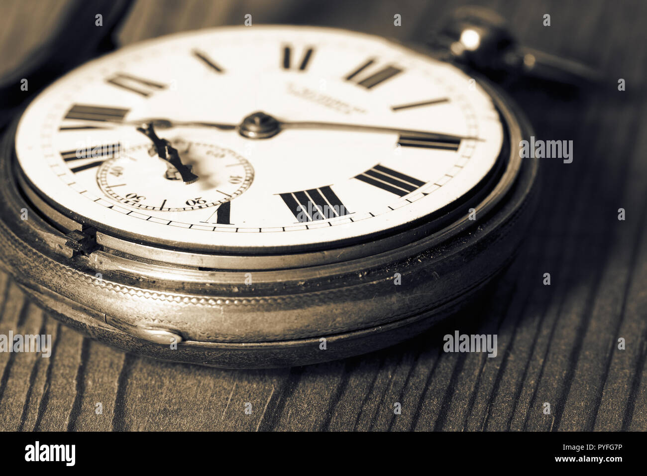 Antique old pocket fob watch on a wood background with sepia toning ...