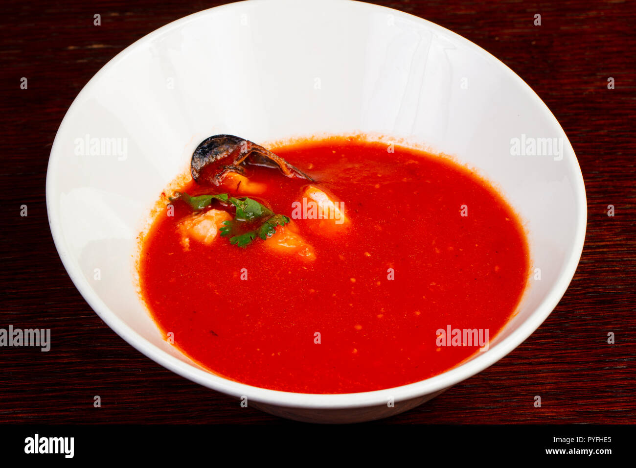 Tomato seafood soup servrd coriander Stock Photo - Alamy