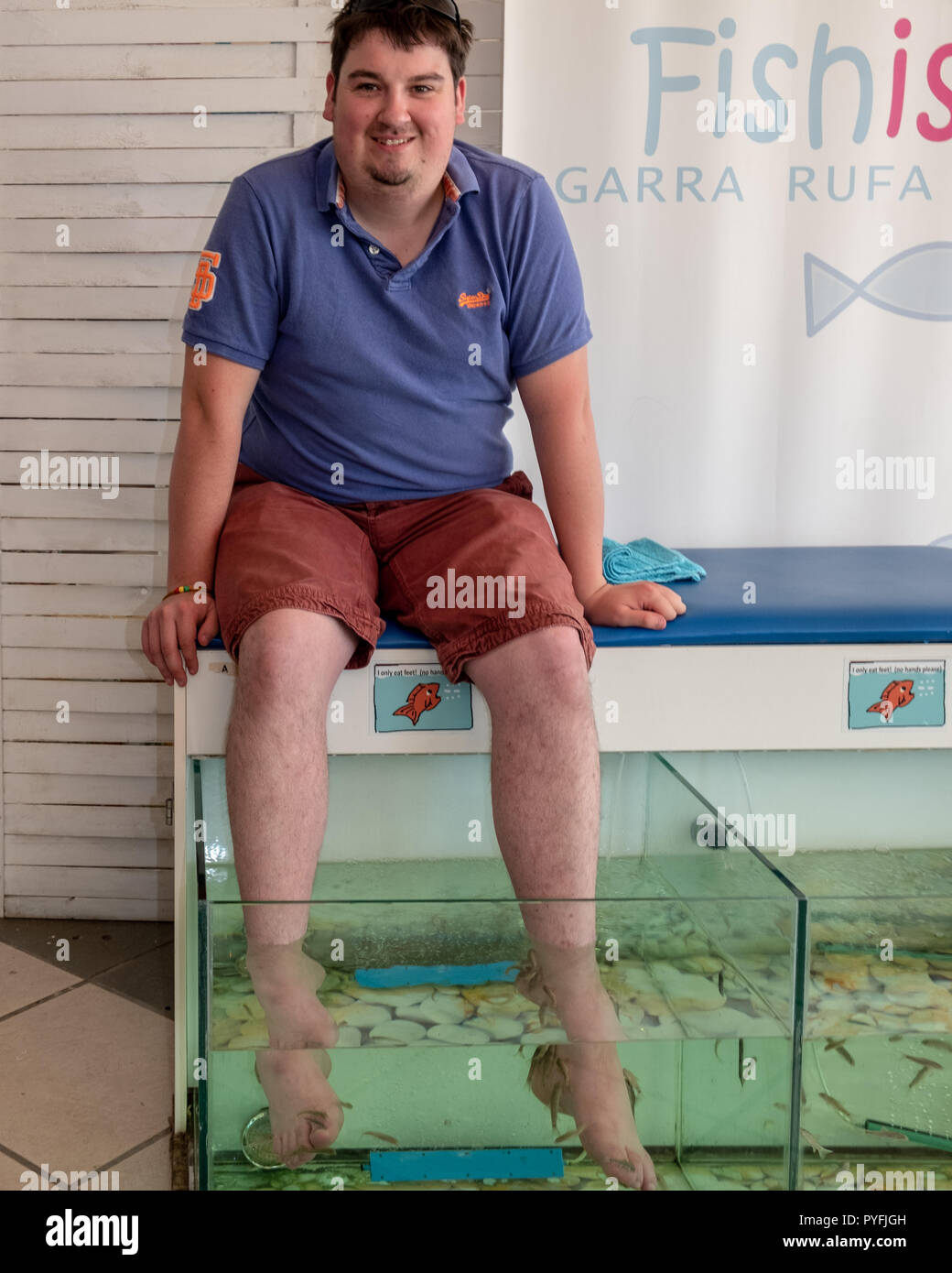 Holiday makers relaxing at a fish spa in Rhodes, Greeece with Garra ...