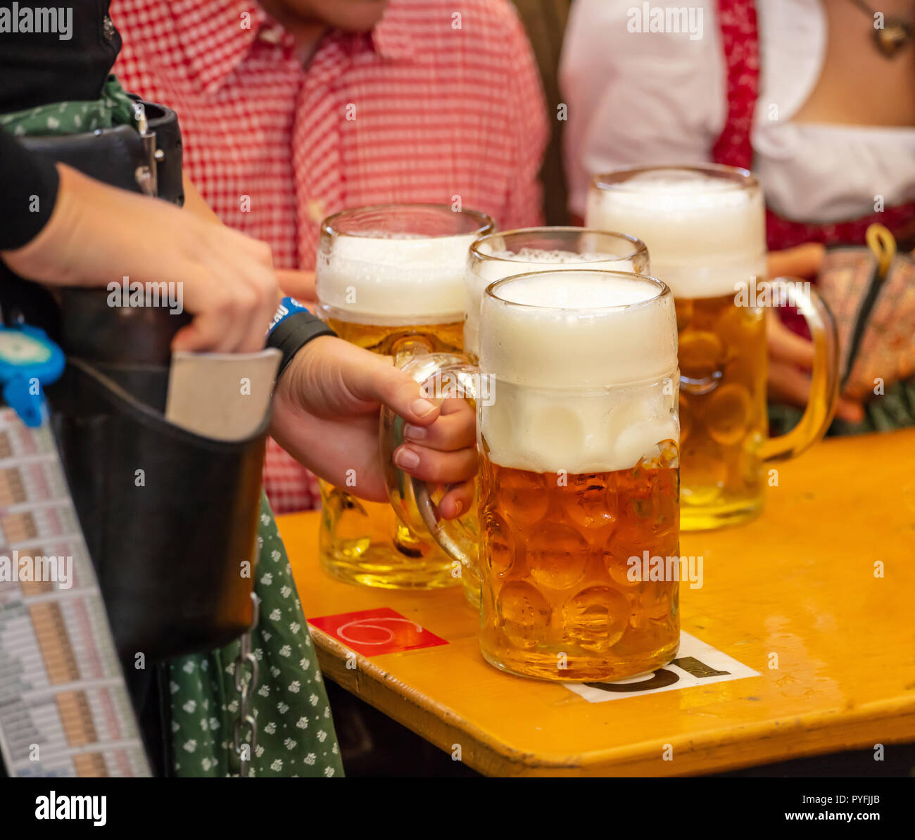 Oktoberfest, Munich, Germany. Woman waiter serving beers, closeup view ...