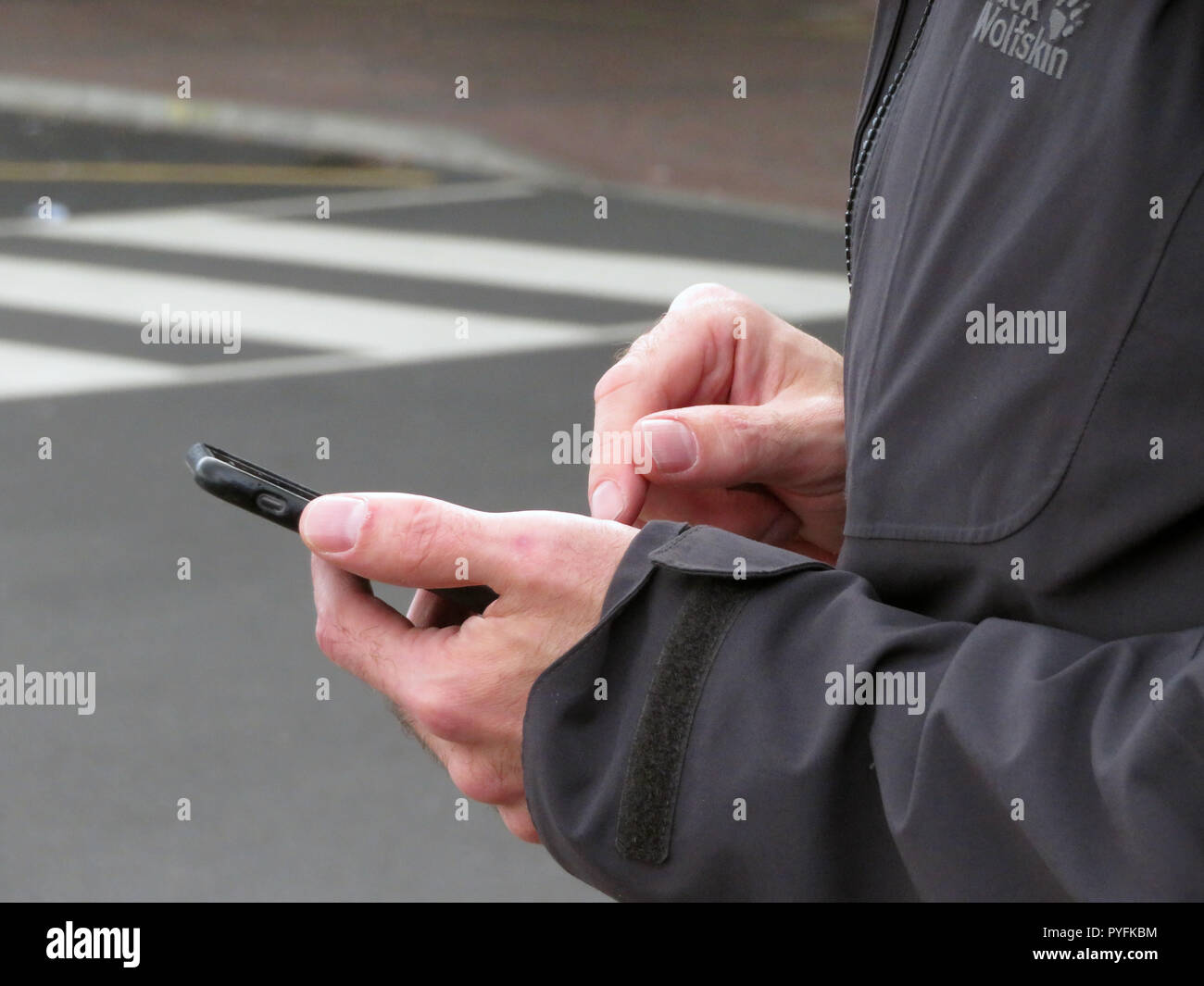 Closeup of Mans fingers using mobile phone at Leeds Bradford Airport ...