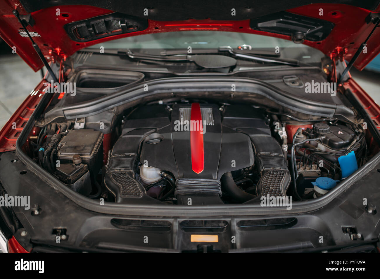 Car with opened hood in automobile service, front view, motor ...