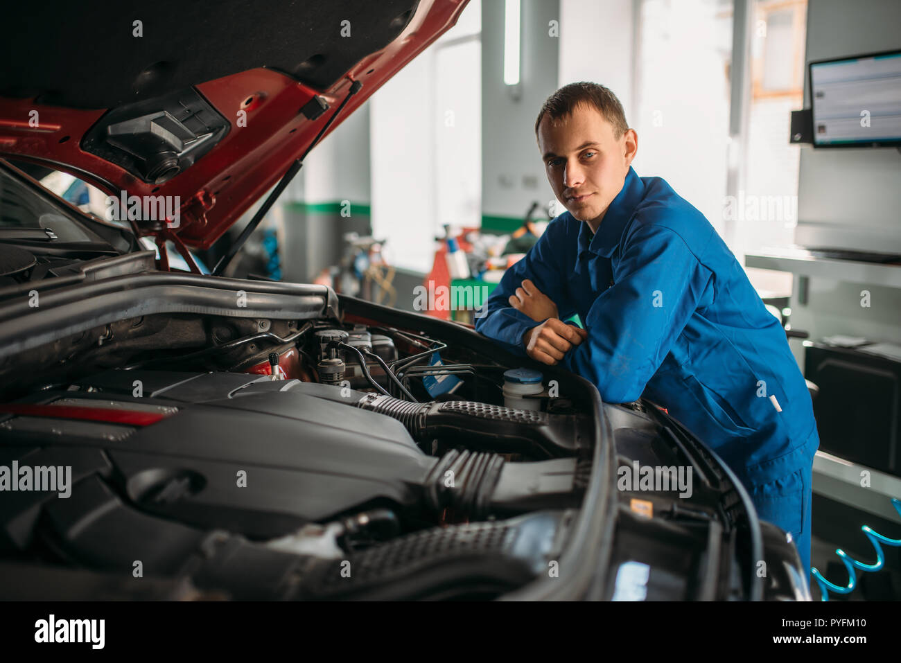 Mechanic makes visual inspection of the car engine, motor diagnostic ...