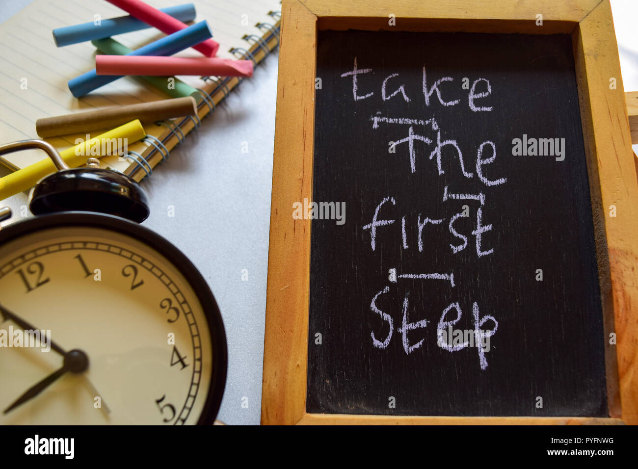 Take the first step phrase colorful handwritten on chalkboard, alarm ...