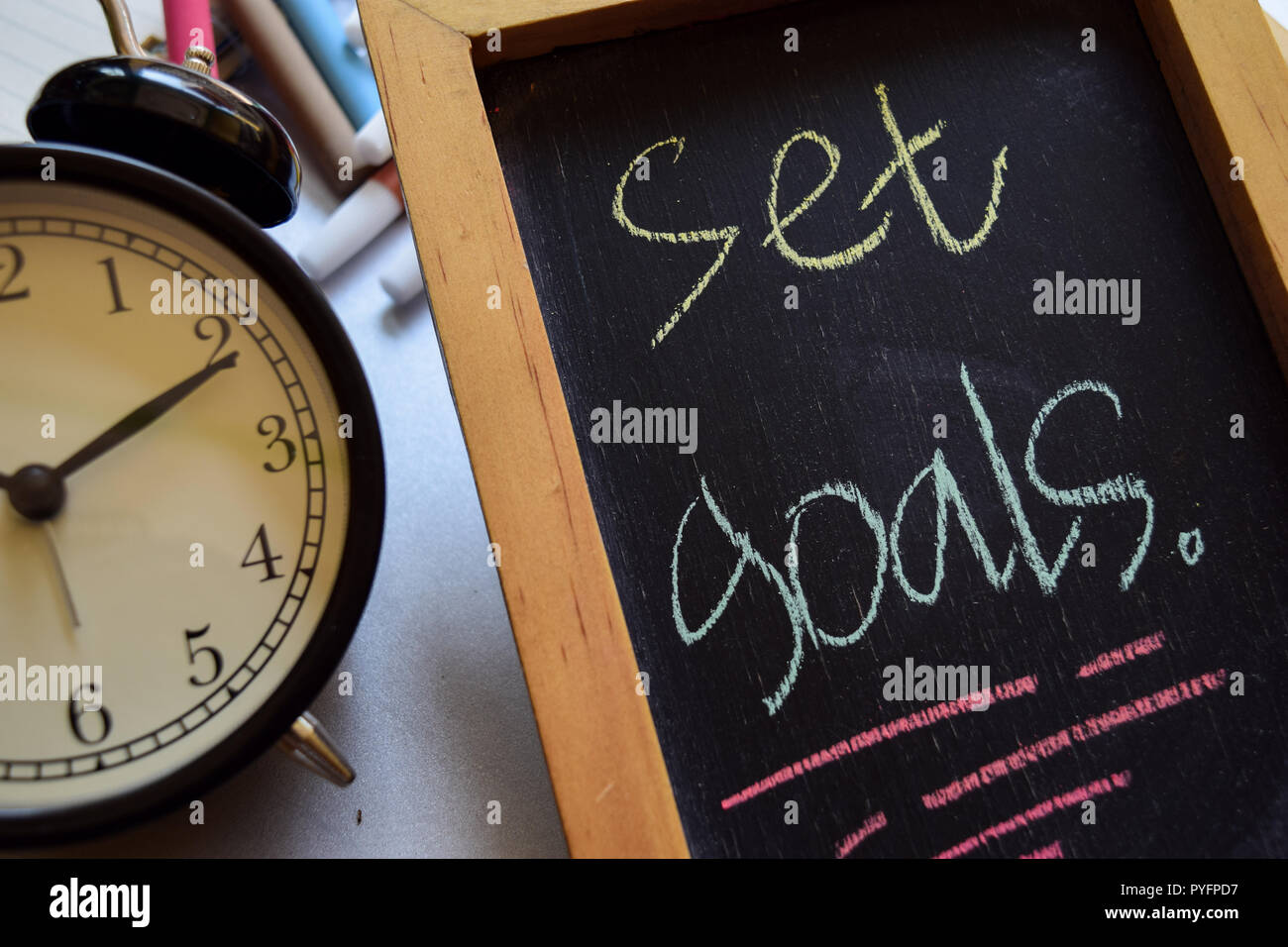 Set goals on phrase colorful handwritten on chalkboard, alarm clock ...