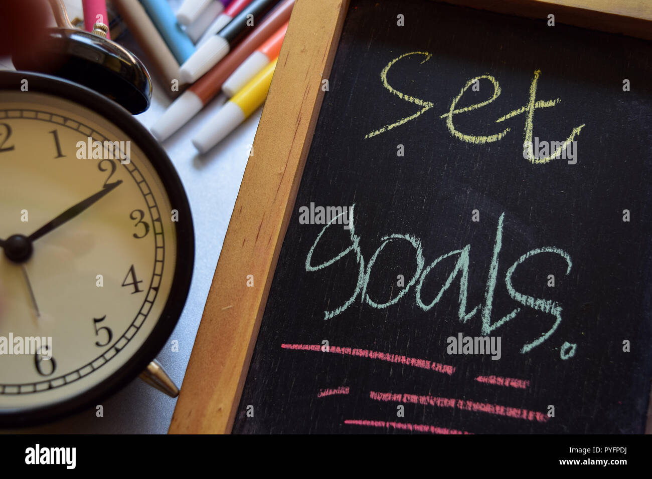 Set goals on phrase colorful handwritten on chalkboard, alarm clock ...