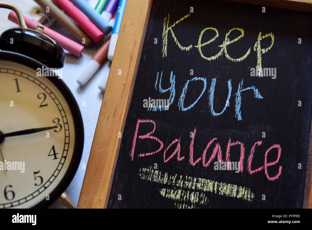 Keep your balance on phrase colorful handwritten on chalkboard, alarm ...