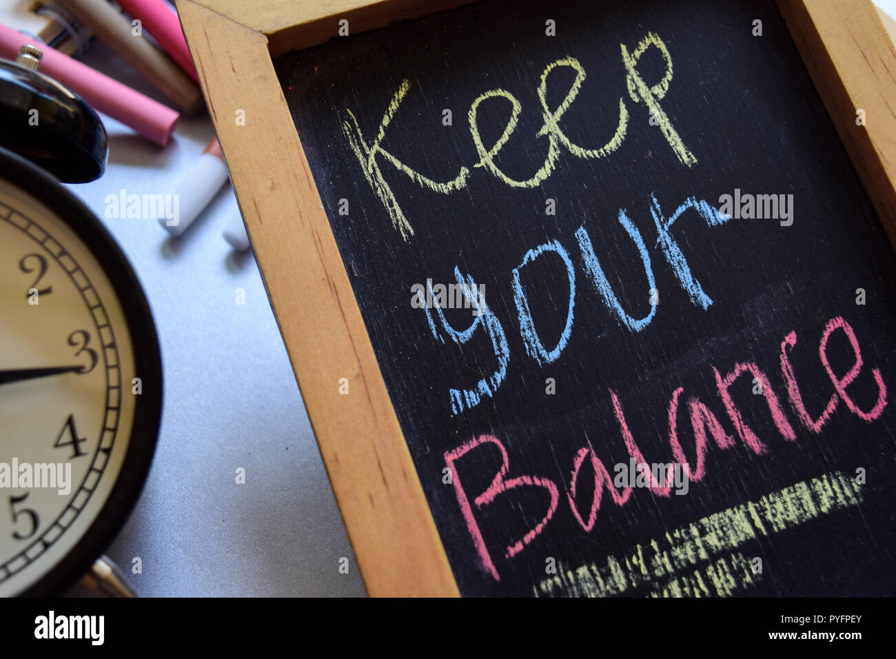 Keep your balance on phrase colorful handwritten on chalkboard, alarm ...