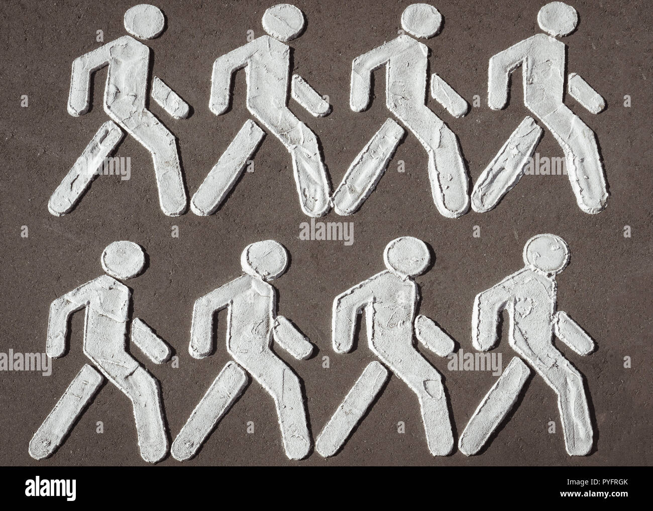 Symbols of men group walking in one line painted on the asphalt road ...