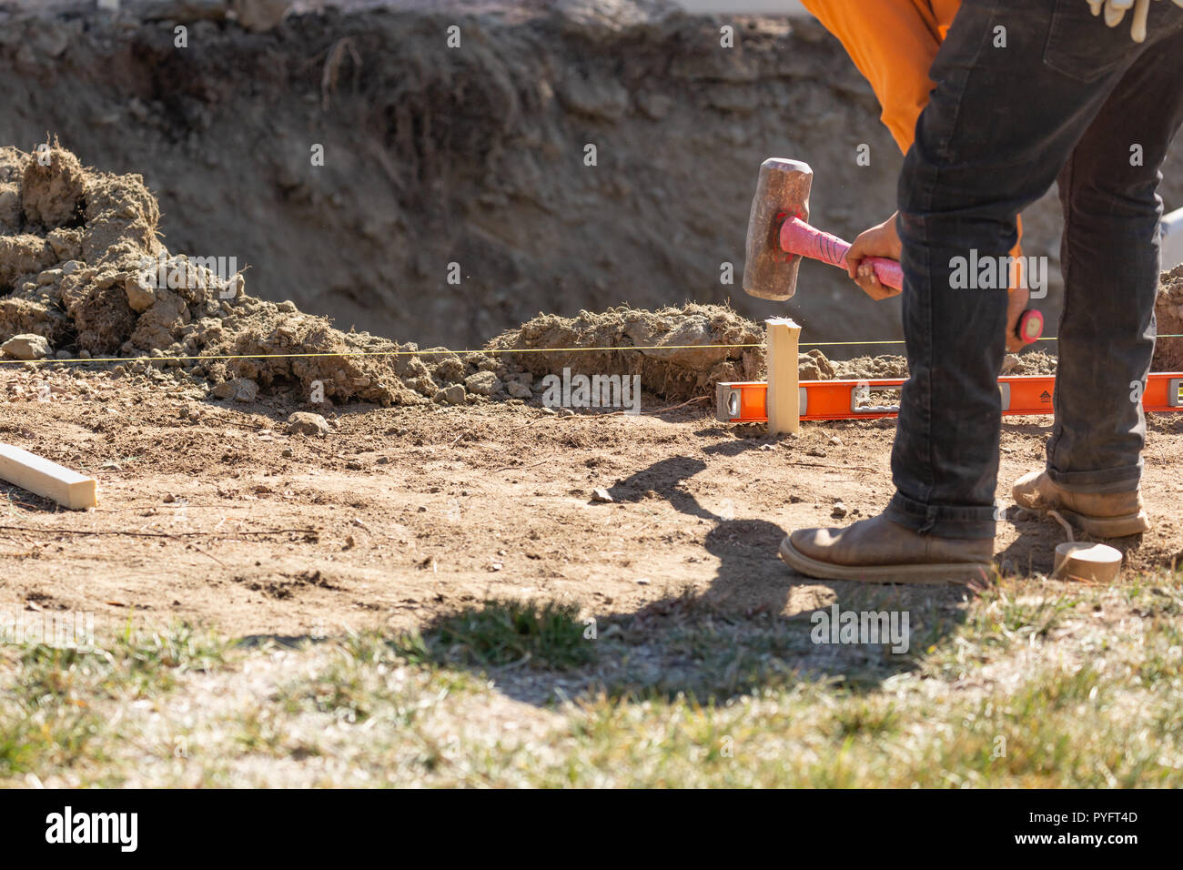 Worker Installing Stakes and Lumber Guides At Construction Site Stock ...