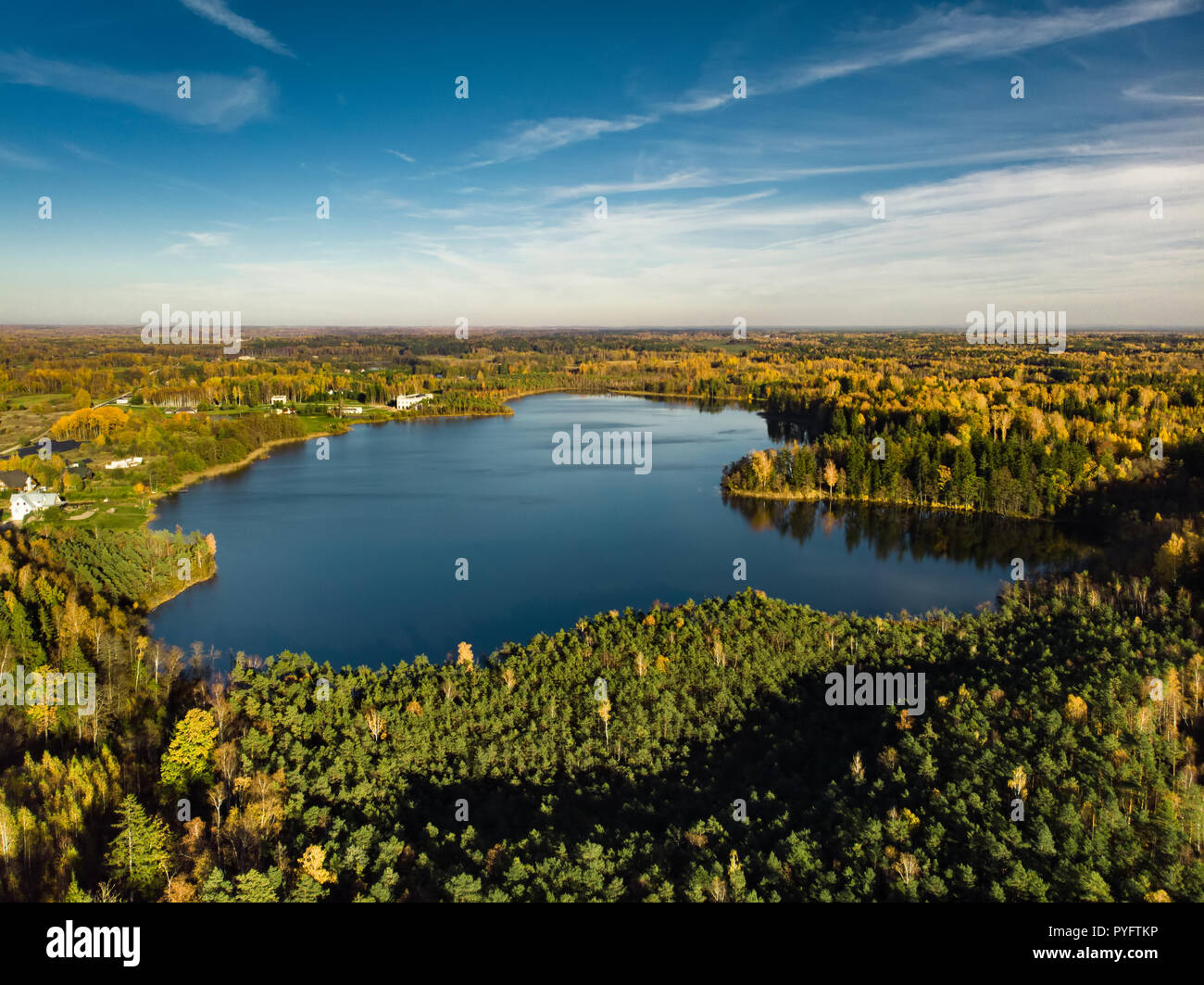 Birds eye view of autumn forest and a small lake. Aerial colorful ...