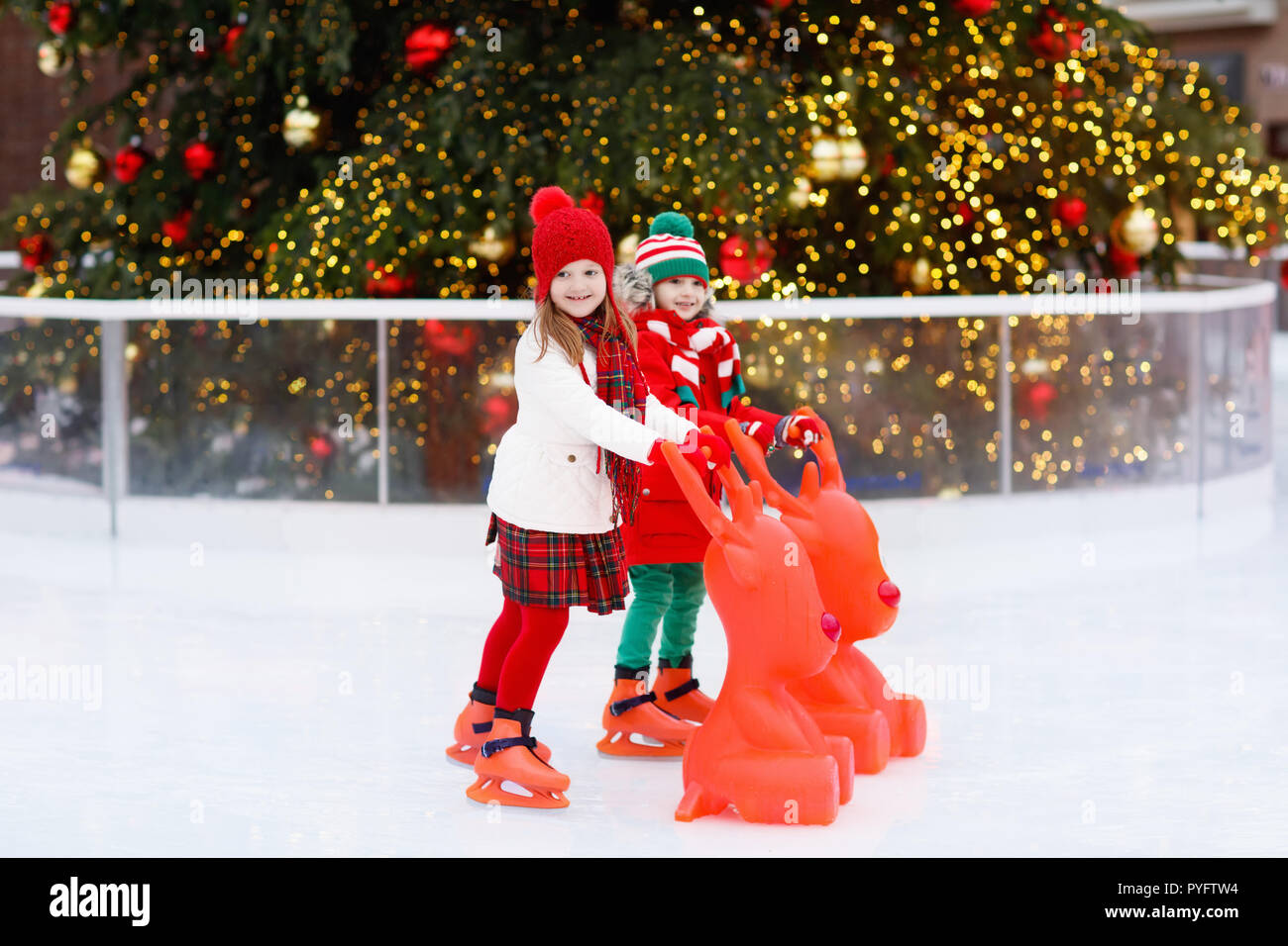 Kids ice skating in winter park rink. Children ice skate on Christmas ...