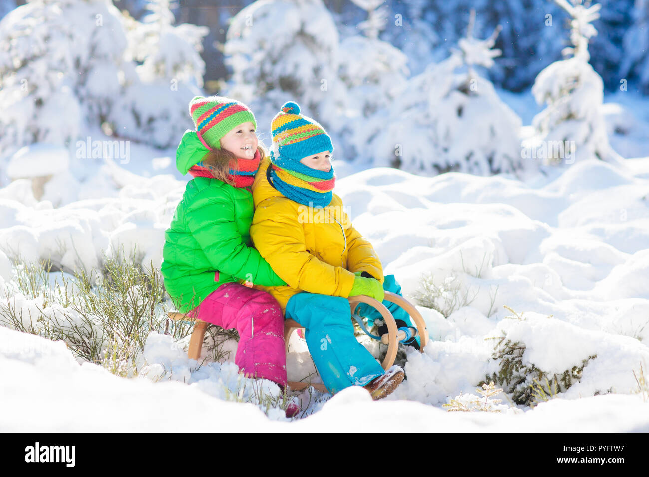 Little girl and boy enjoying sleigh ride. Child sledding. Toddler kid ...