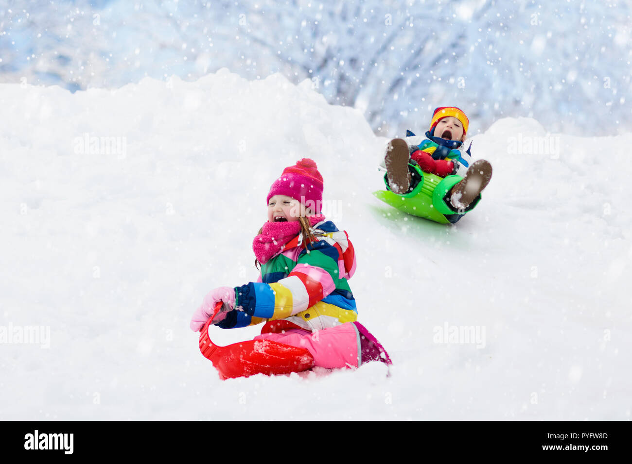 Little girl and boy enjoying sleigh ride. Child sledding. Toddler kid ...