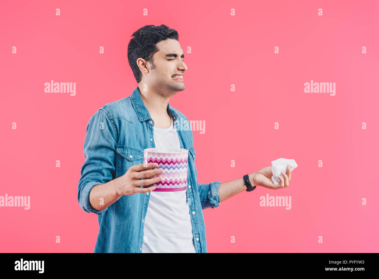 emotional young man with tissue box crying and gesturing by hands ...