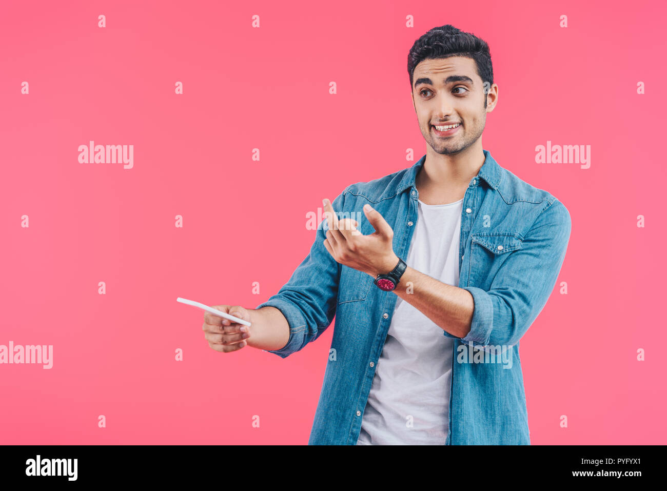 portrait of man with smartphone showing middle finger isolated on pink ...