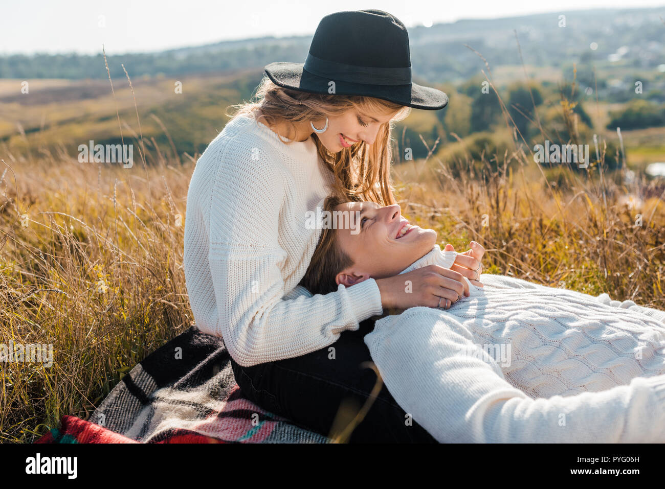 beautiful girlfriend looking on boyfriend on meadow Stock Photo - Alamy