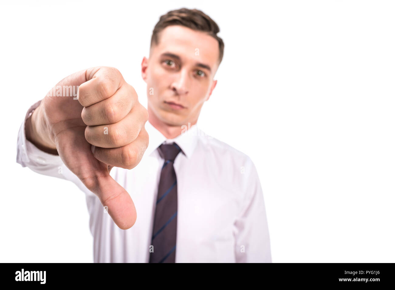 selective focus of man showing thumb down and looking at camera ...