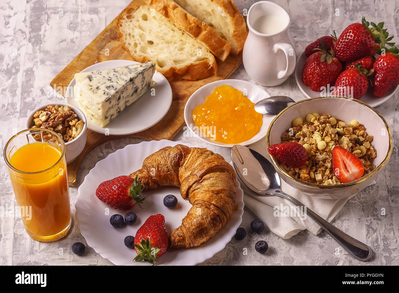 Healthy Breakfast with milk in a small jur, granola, strawberry, nuts ...