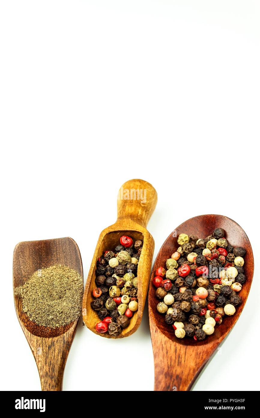 Pepper in wooden spoon. Mix of different peppers balls on white ...
